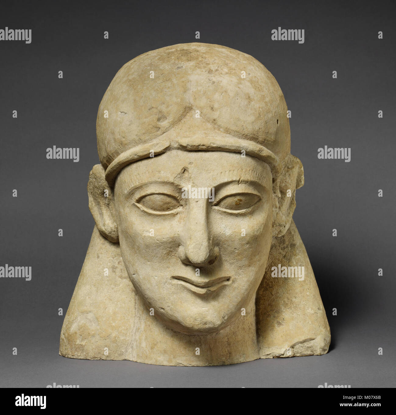 The limestone head depicts a beardless male figure wearing a fillet ...