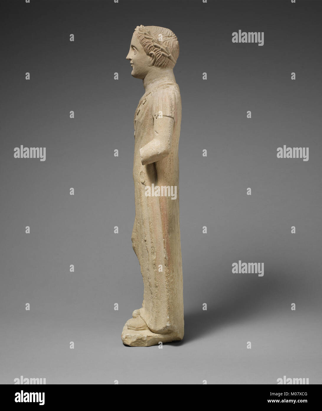 This limestone statuette of a boy adorned with a chain of amulets ...