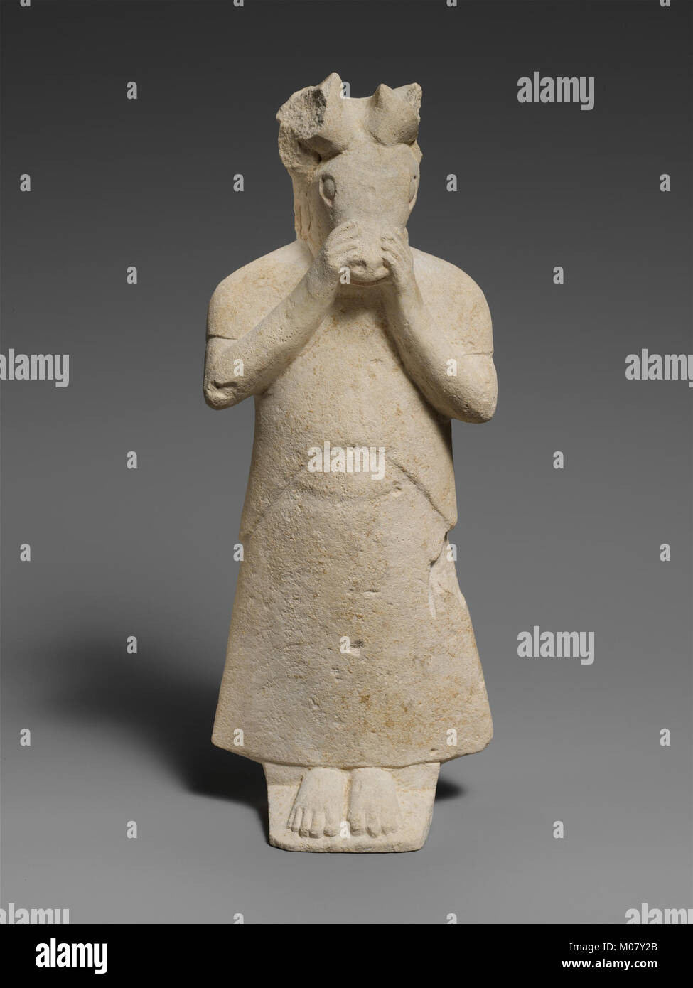 A limestone figure with a mask, depicting a human form in ancient art ...