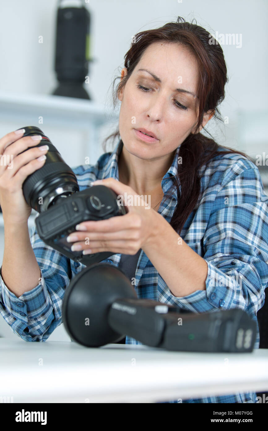 female photographer adjusting a camera tripod Stock Photo - Alamy