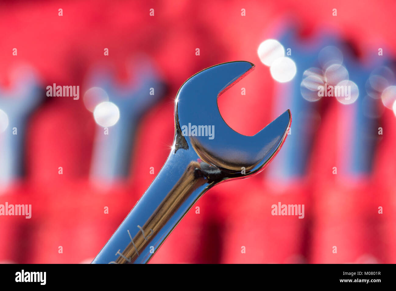 Focusing on a single steel spanner with a spanner kit of shiny metal ...