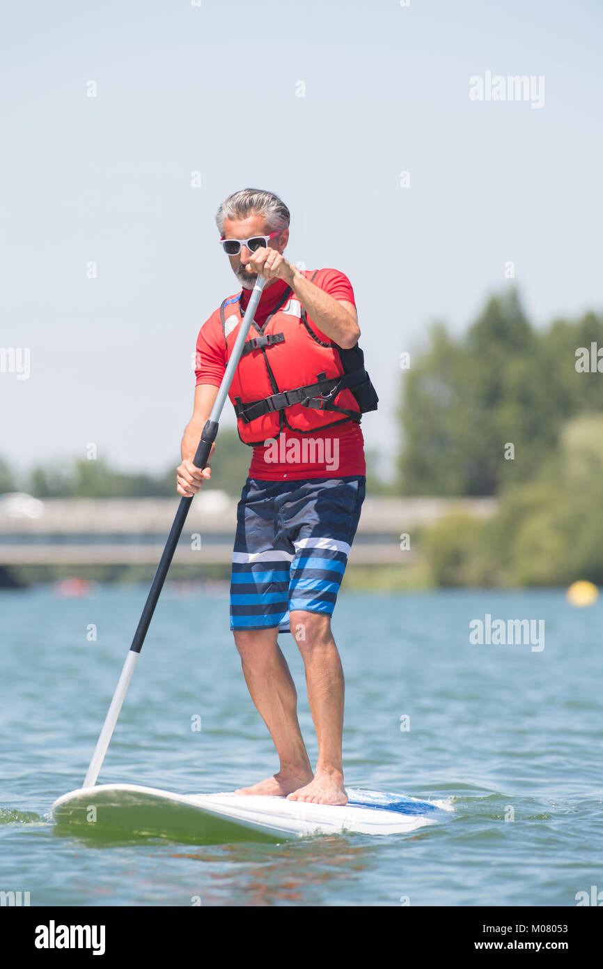 man enjoying a ride on the lake with paddleboard Stock Photo - Alamy