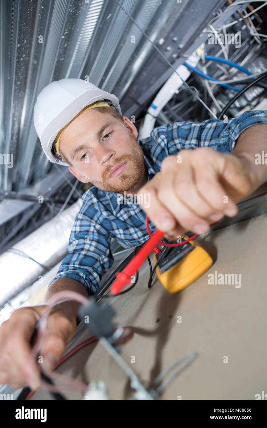 Electrician testing spotlight with multimeter Stock Photo - Alamy