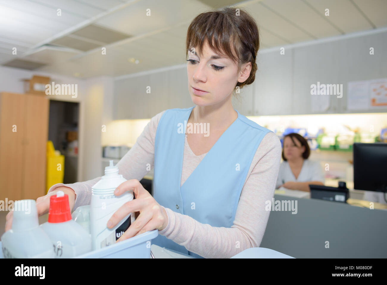 female cleaner in uniform preparing cleaning equipment in hospital ...