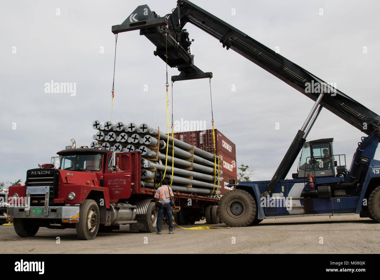 Power pole shipments are loaded onto trucks at a pier in San Juan ...
