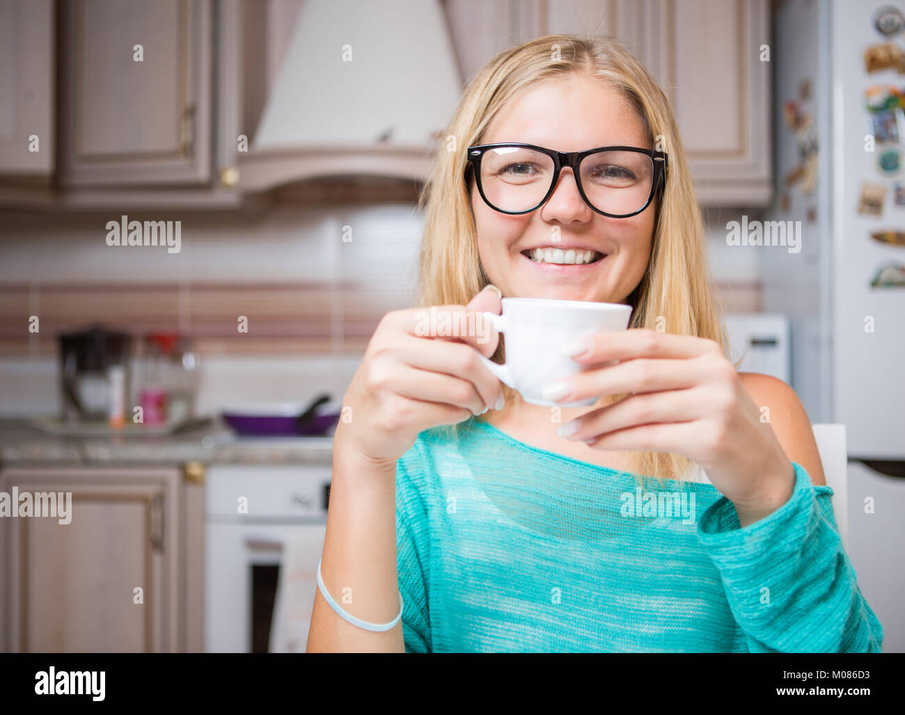 Girl with cup in kitchen Stock Photo - Alamy