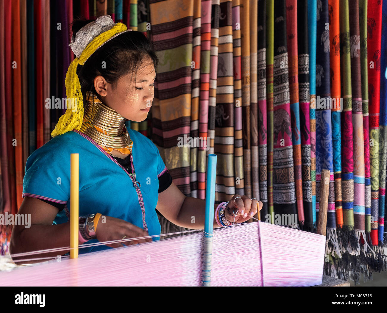 Long neck tribal woman weaving silk in her village, Thailand Stock ...