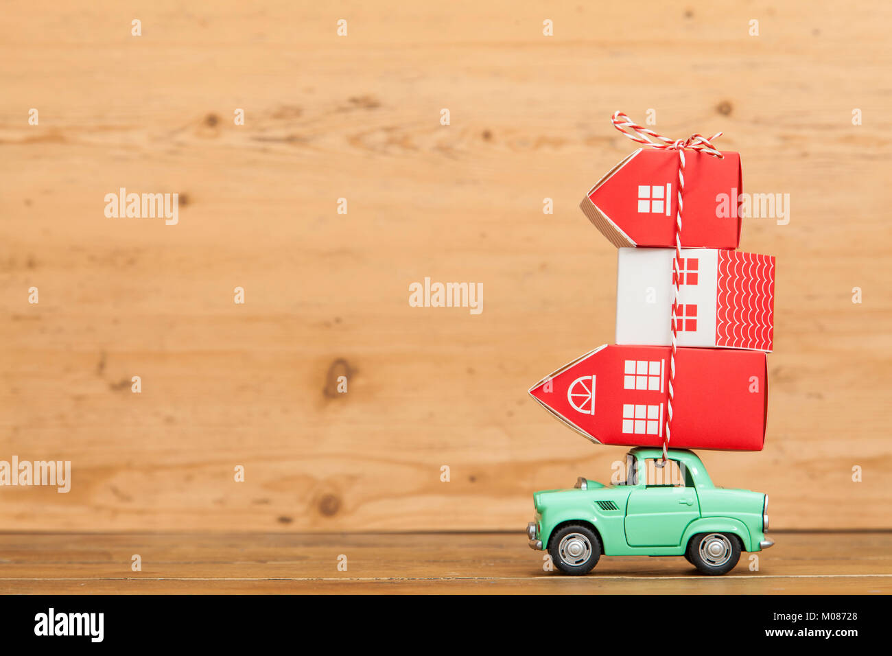Toy car carrying a stack of houses. Moving house concept Stock Photo ...