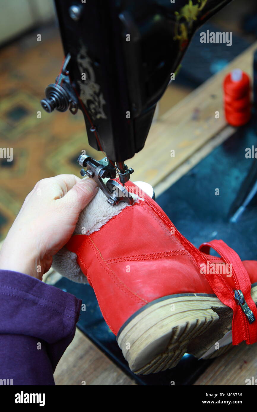 in a Shoe shop shoemaker sews on the sewing machine lock-on boots Stock ...