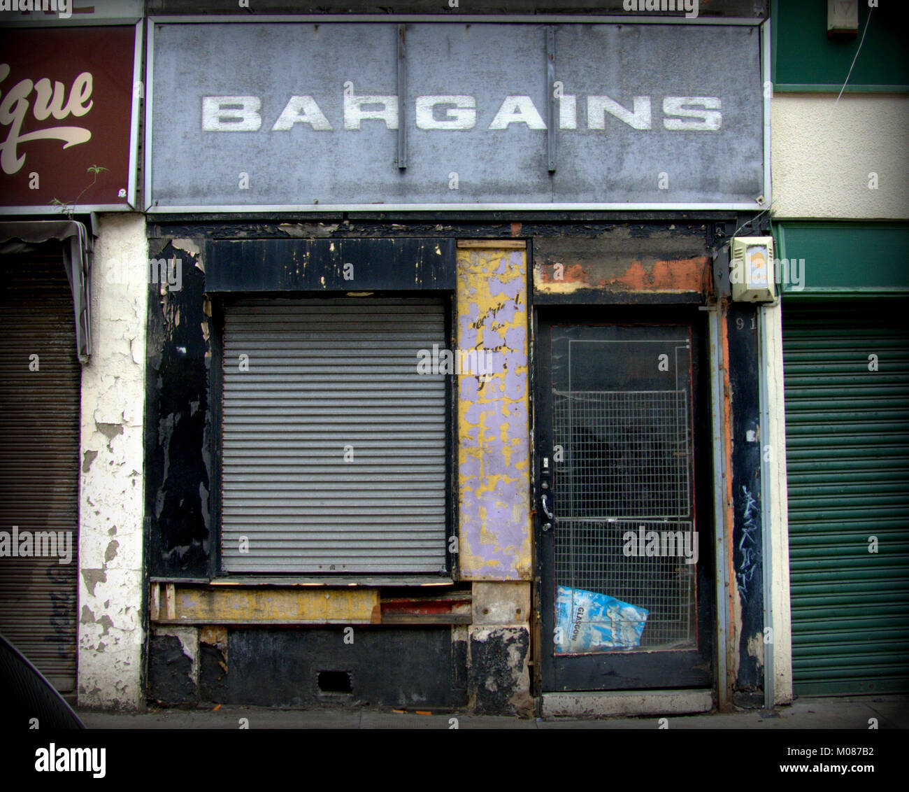 bargains sign on dilapidated run down abandoned shop front facade near ...