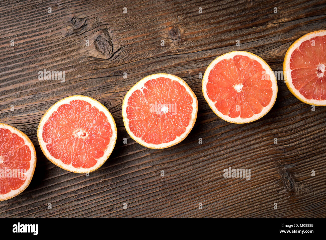 Red grapefruits on an old wooden table Stock Photo - Alamy