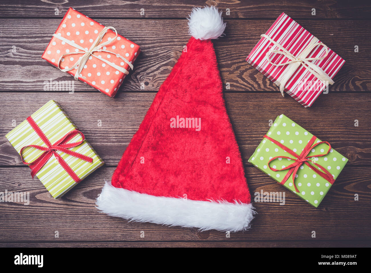 Santa Claus red hat with colorful gift boxes Stock Photo - Alamy