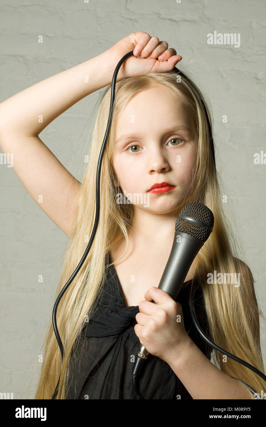 Pretty blond girl with microphone Stock Photo - Alamy