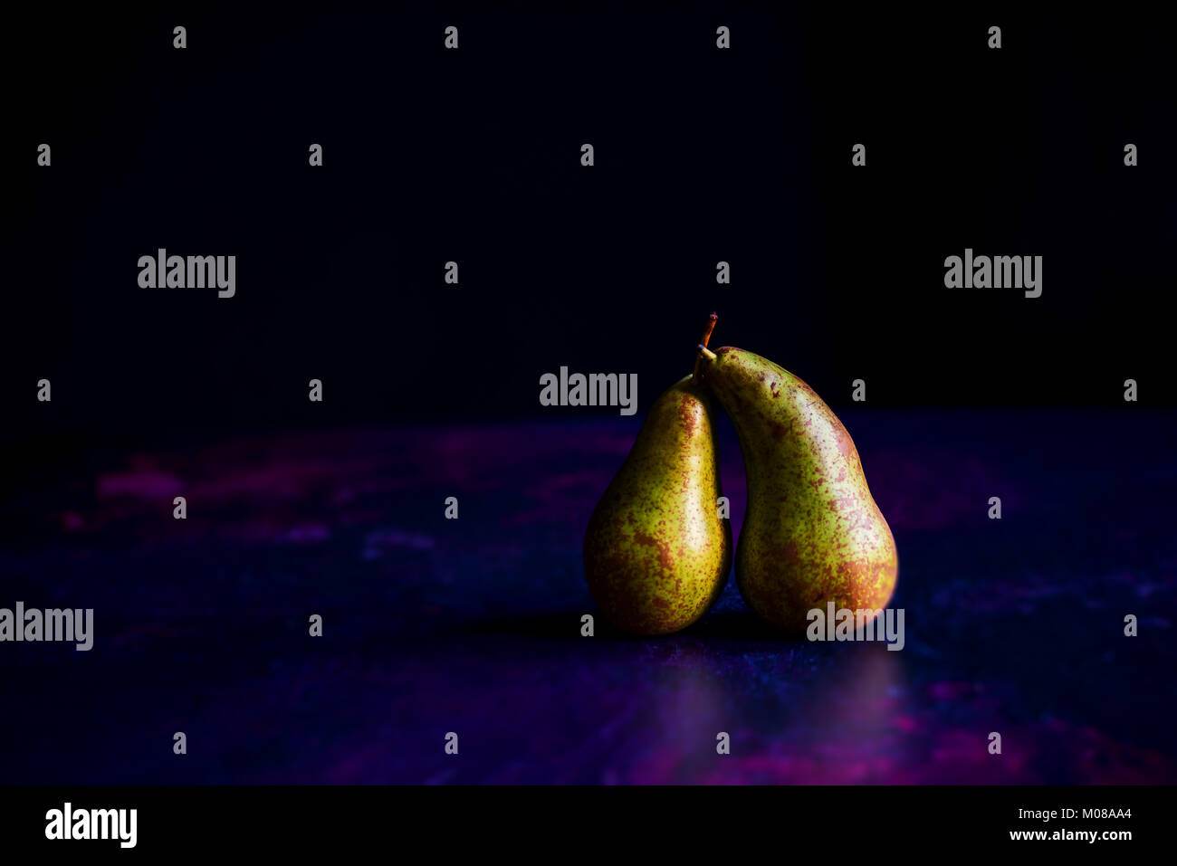 Two pears stood together with purple background Stock Photo - Alamy