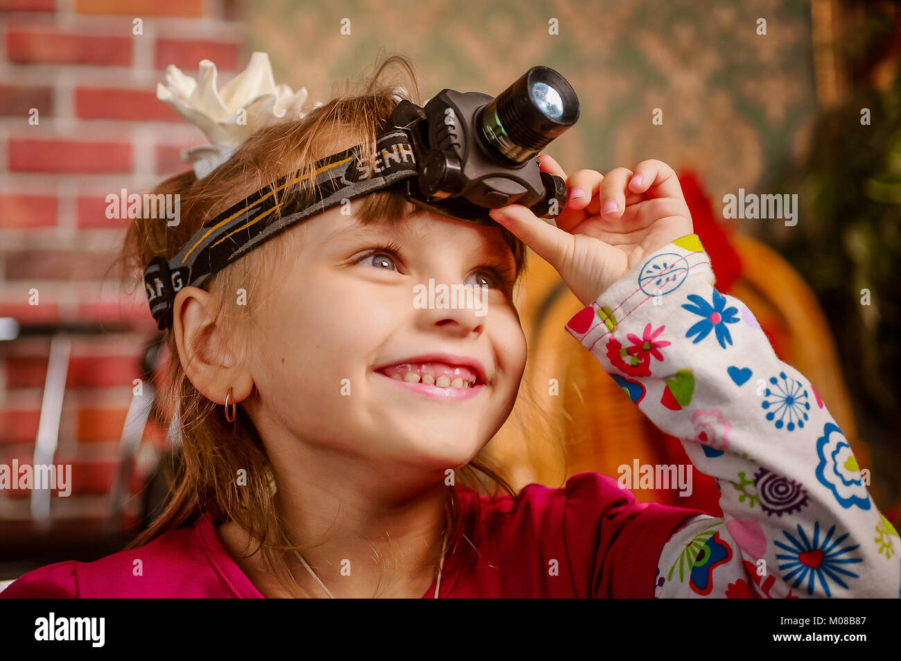 Portrait of a smiling little girl with a flashlight on his head Stock ...