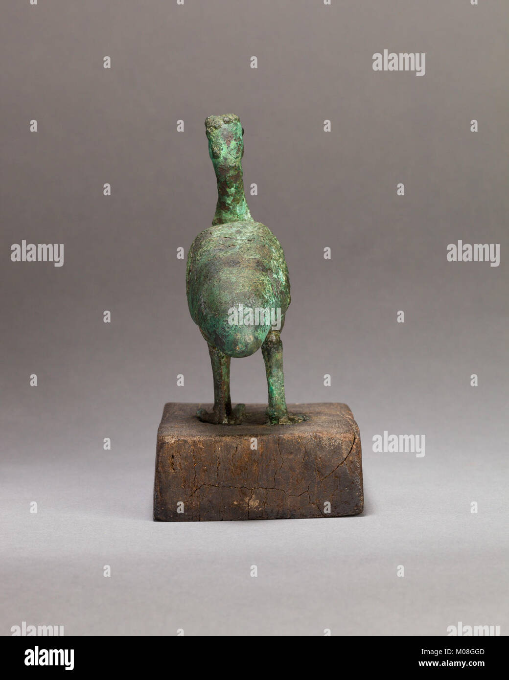 This sculpture features an ibis mounted on a wooden base, capturing the ...