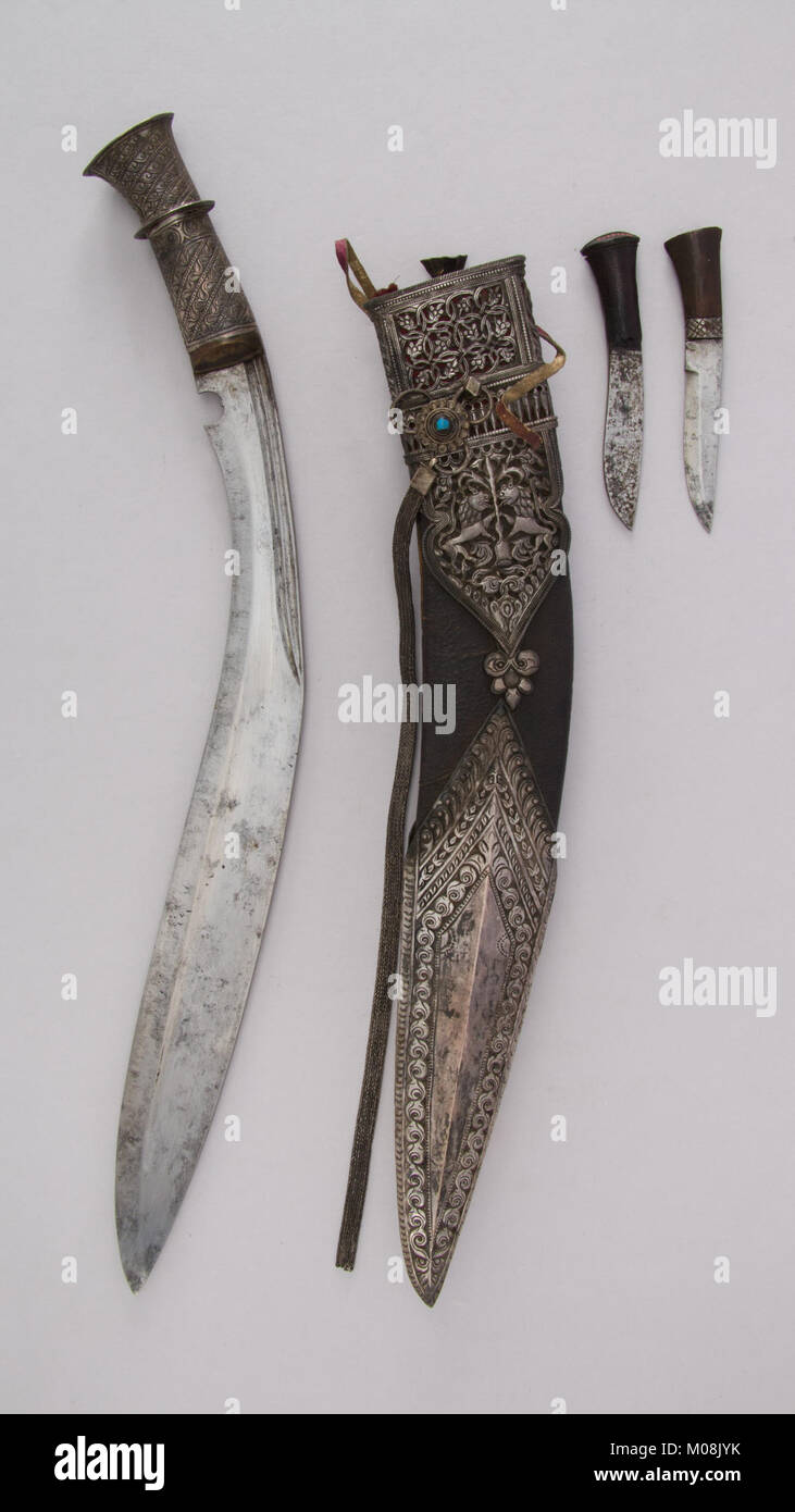 This kukri set, featuring a large curved blade, two small knives, and a ...