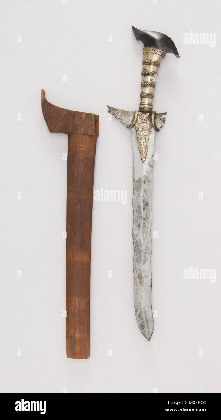 Traditional kris dagger with wavy blade and sheath, highlighting ...