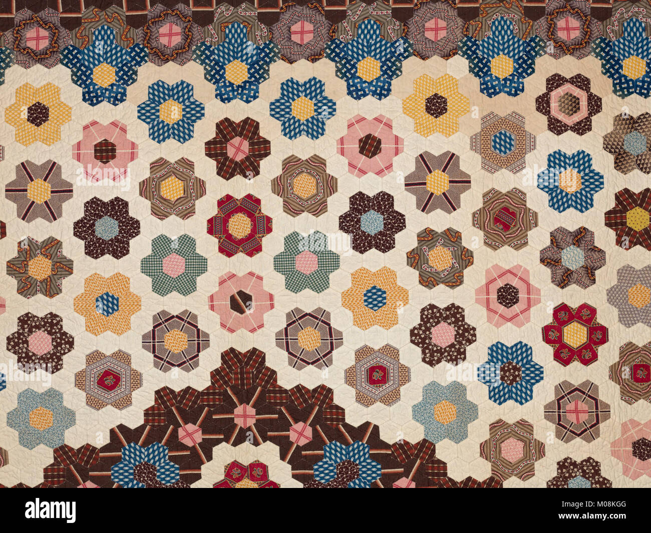 This honeycomb quilt features intricate stitching and geometric ...
