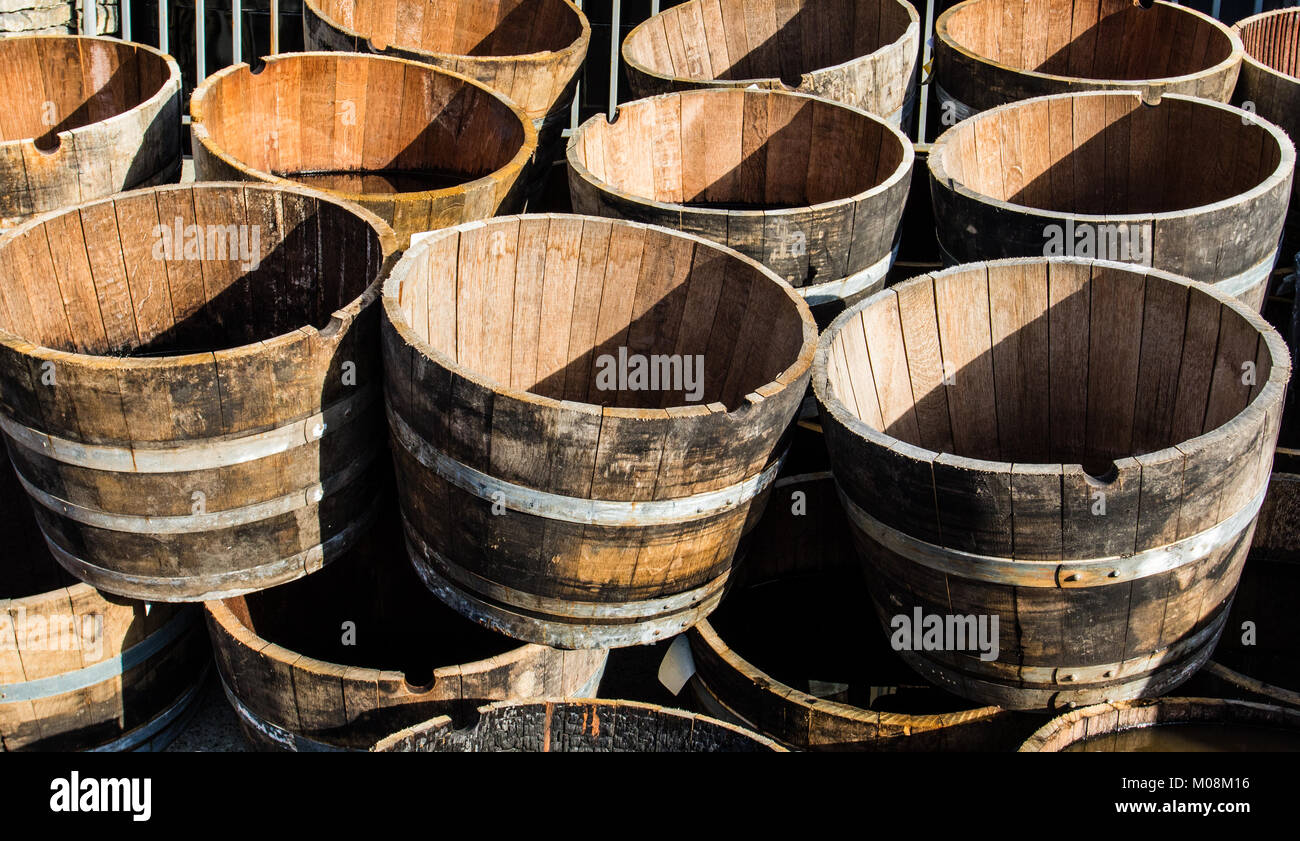 Old wooden half barrels. Ex wine casks having a second life to be used ...