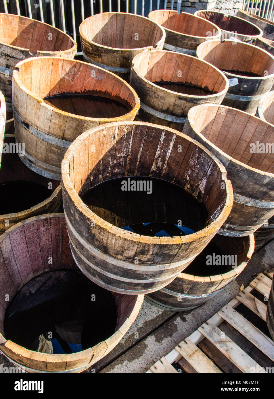 Old wooden half barrels. Ex wine casks having a second life to be used ...
