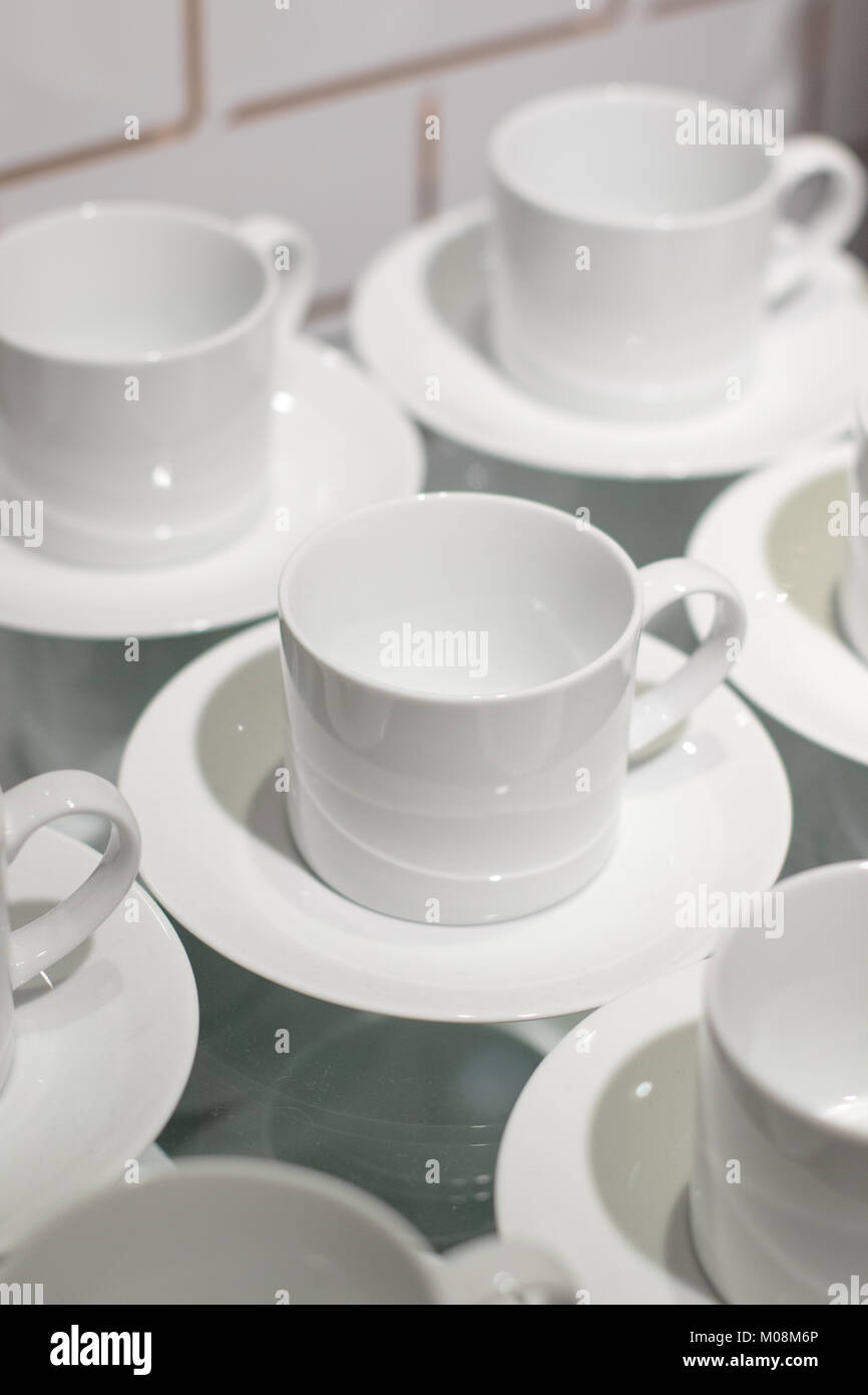 White ceramic cups set on display Stock Photo - Alamy
