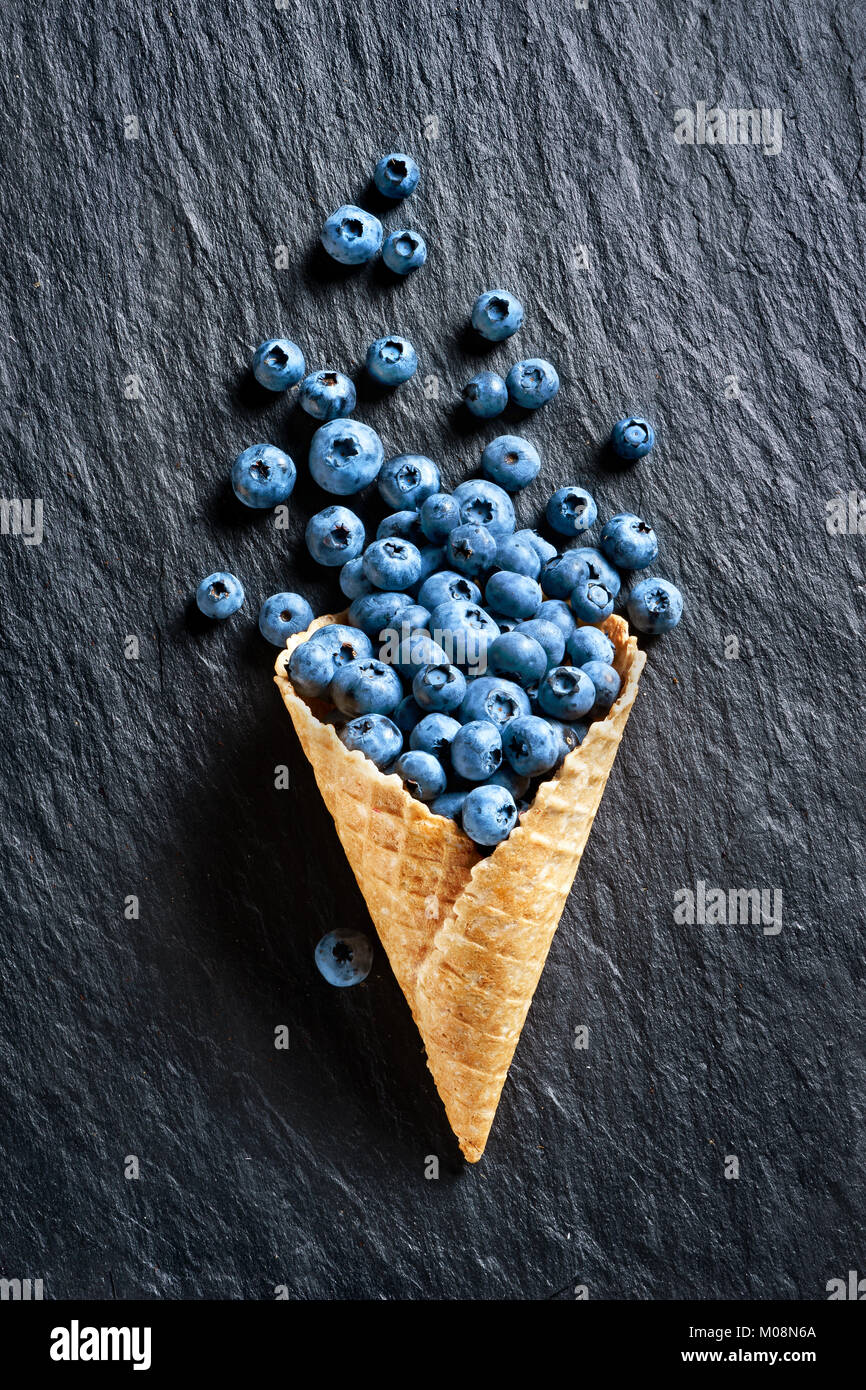 Blueberry explosion. Photo of blueberry in waffle cone on black slate ...