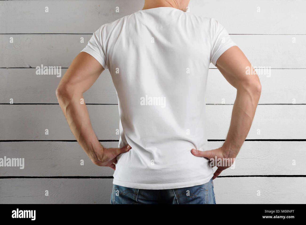young guy in a white t-shirt for a Mockup. A view of the back of a man ...