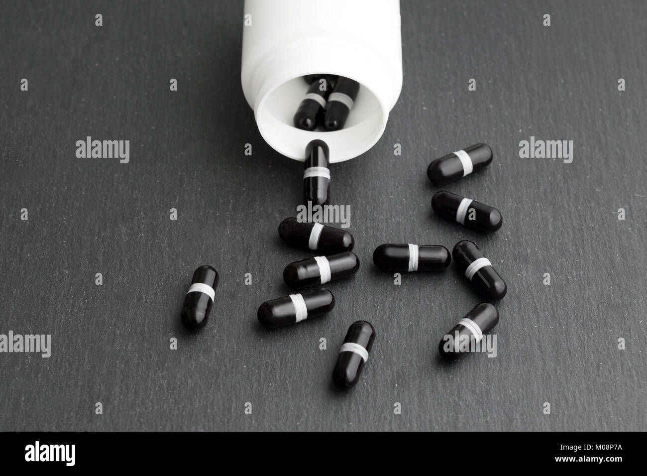 Capsules pouring from bottle container hi-res stock photography and ...
