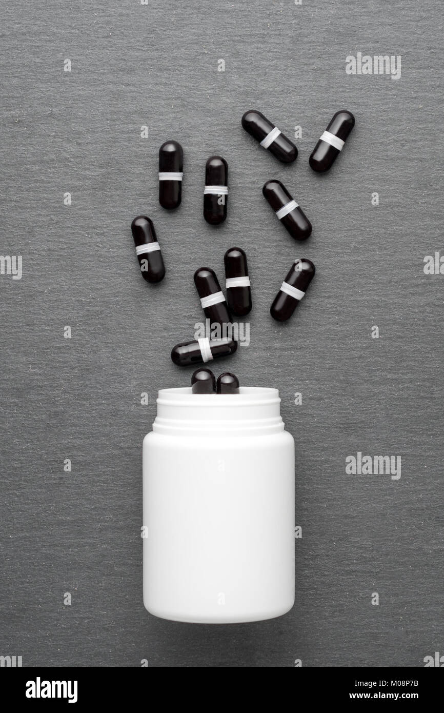 Capsules pouring from bottle container hi-res stock photography and ...