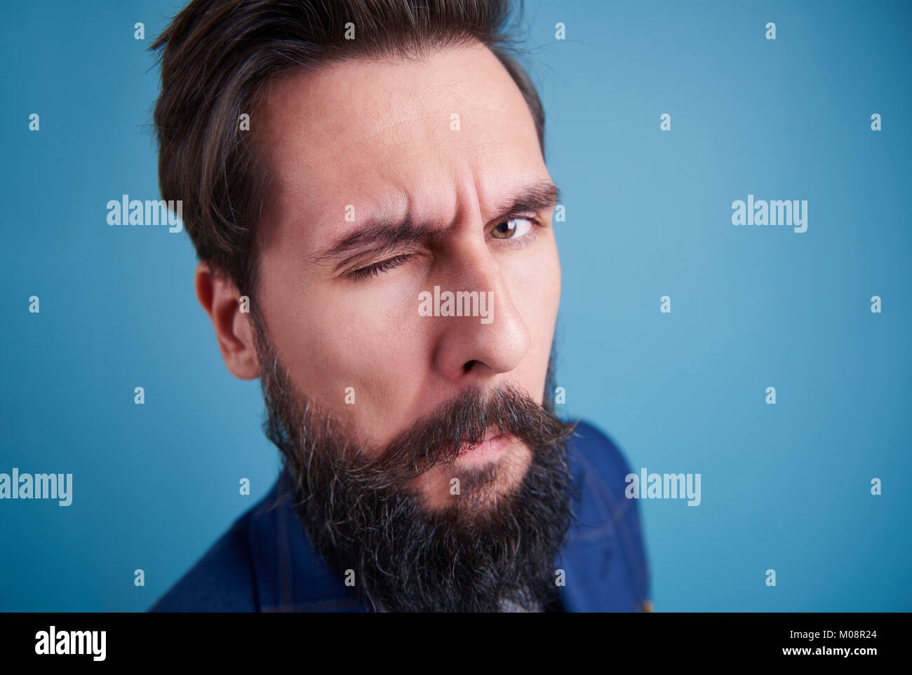 Handsome man with beard winking Stock Photo - Alamy