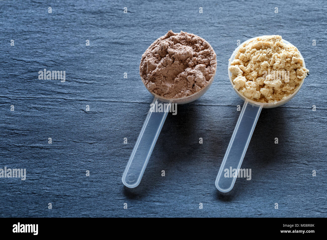 Plastic measuring spoons filled with meal replacement powder against ...