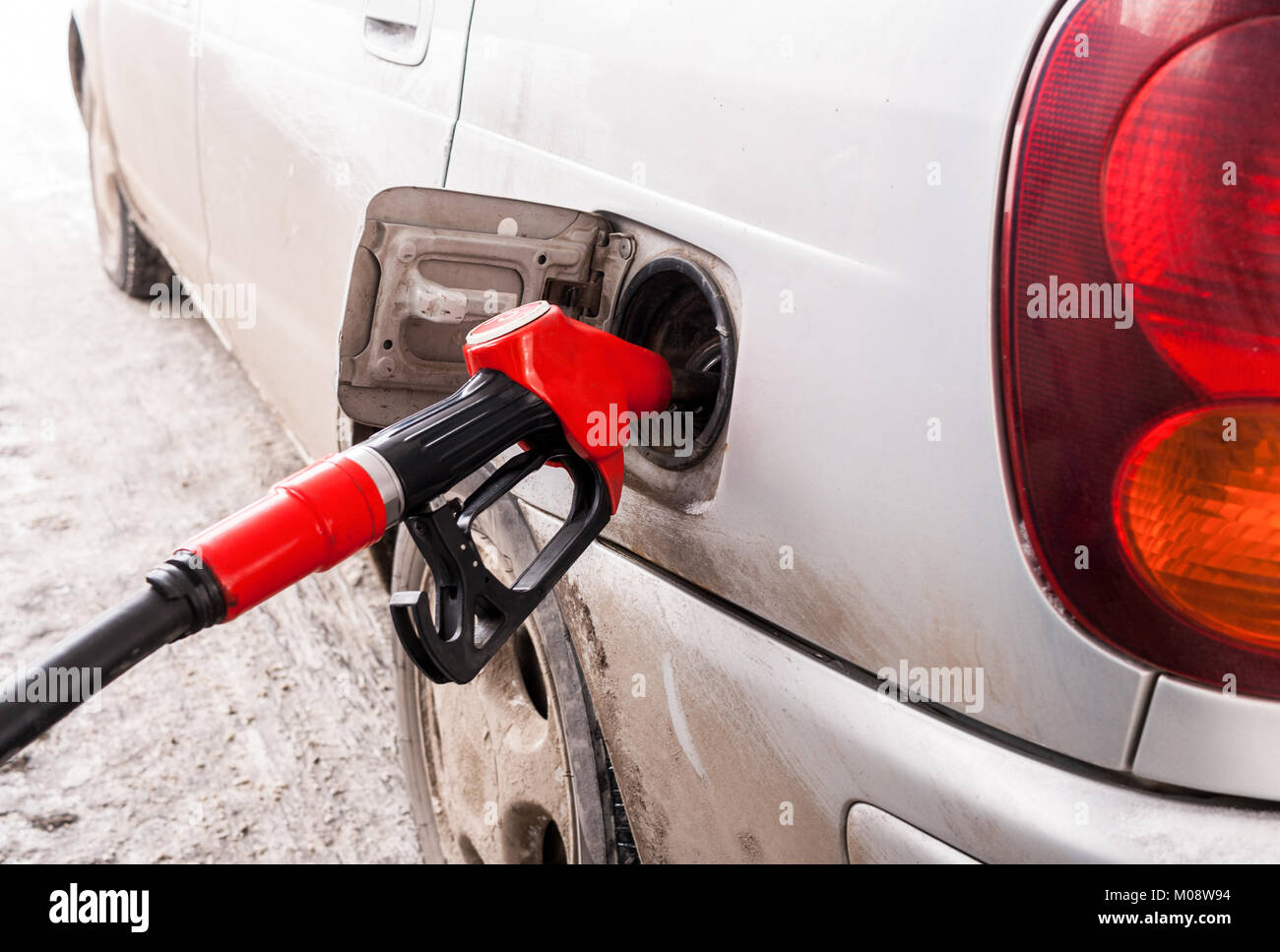 Filling hose with gasoline is inserting in fuel hole gray car Stock ...