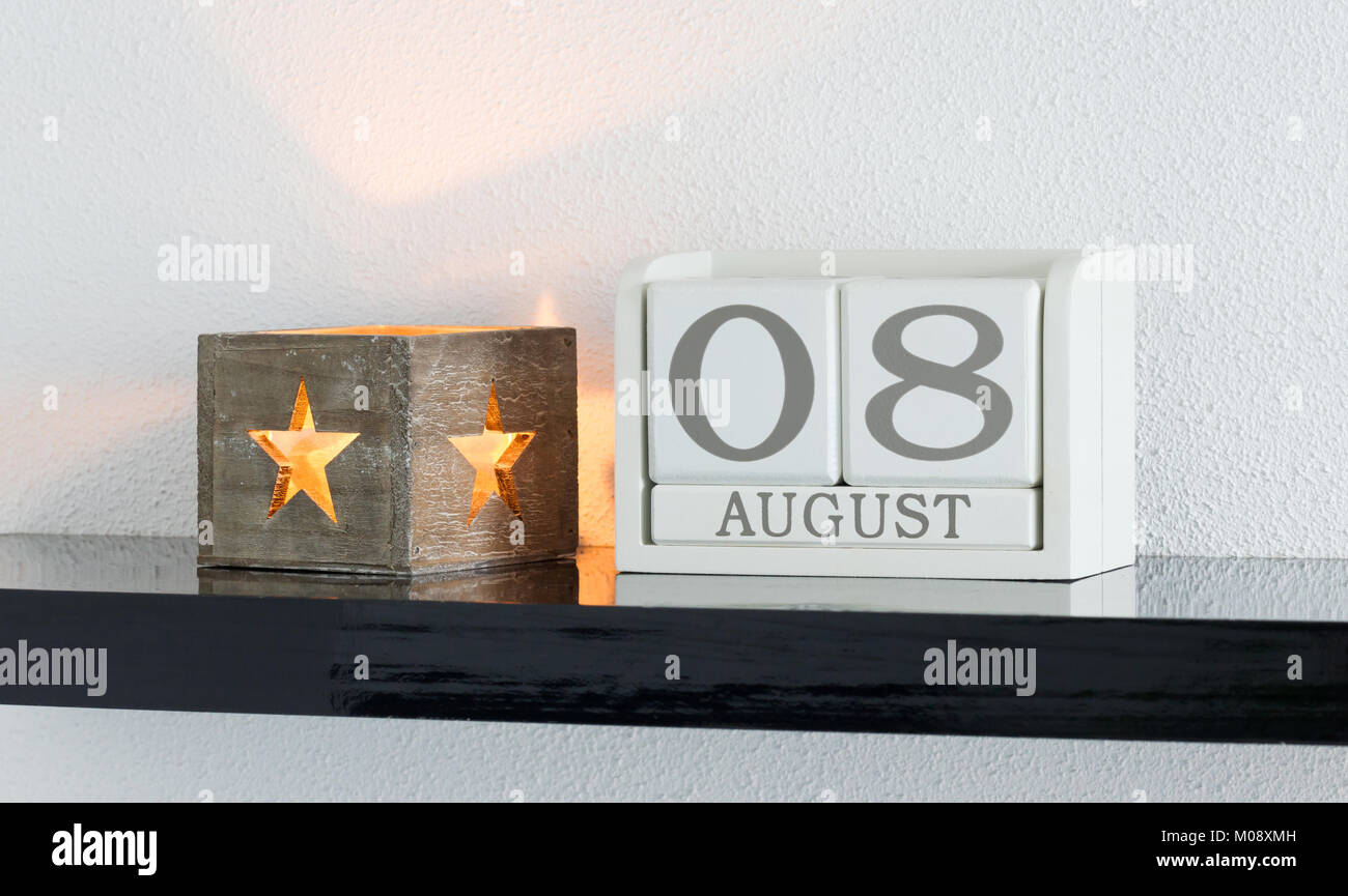 White block calendar present date 8 and month August on white wall ...