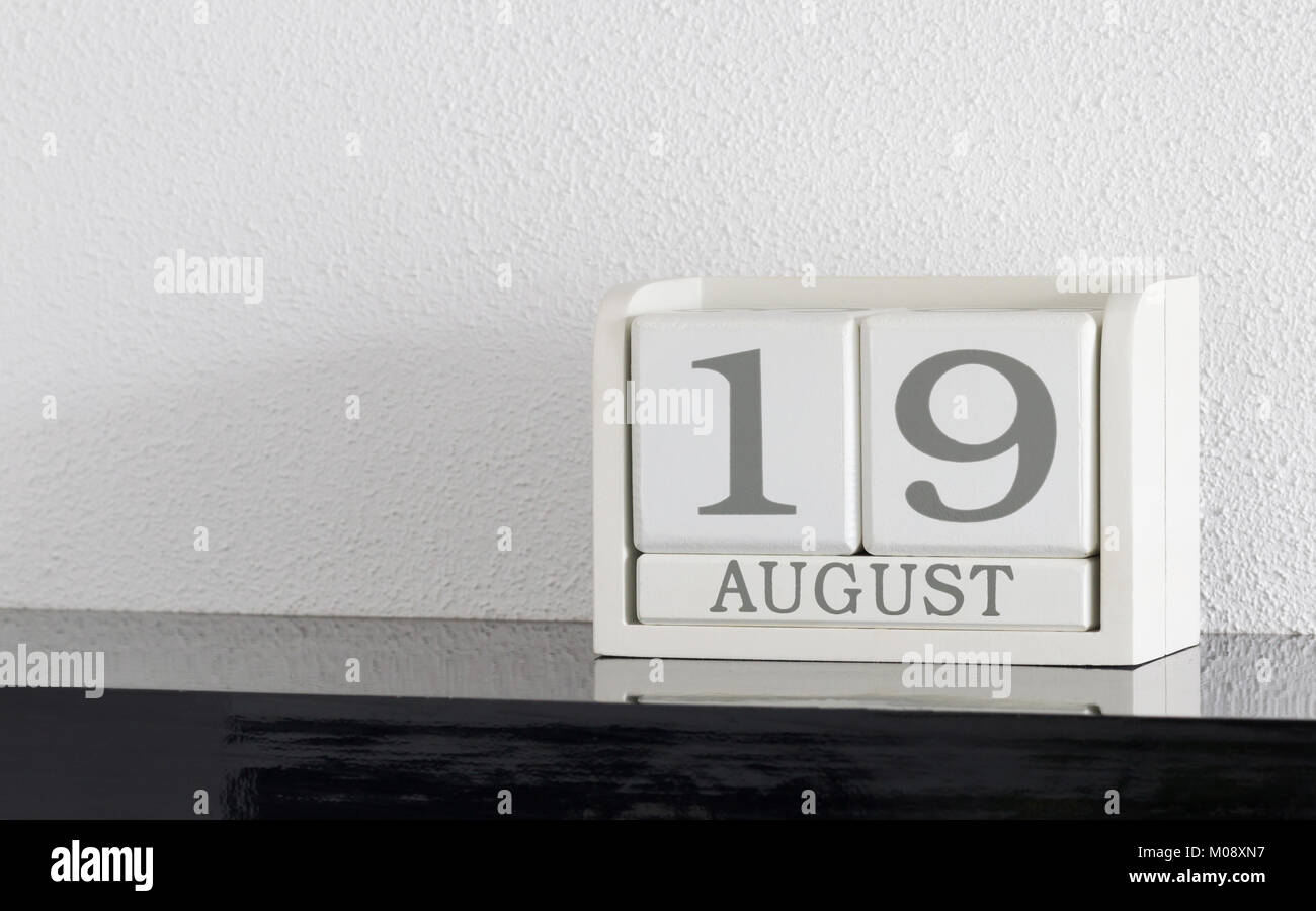 White block calendar present date 19 and month August on white wall ...
