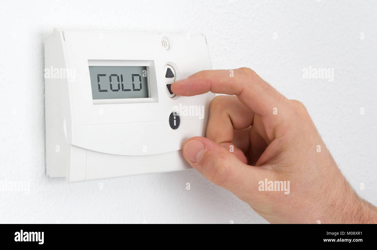 Vintage digital thermostat - Cold - Man adjusting the temperature Stock Photo - Alamy