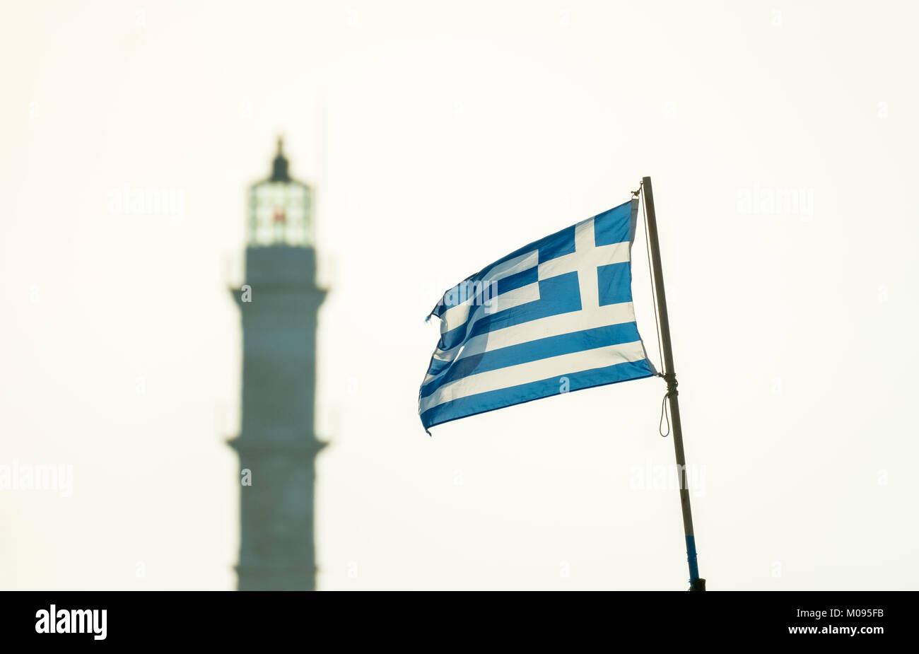 Greek flag in front of the lighthouse of Chania, Chania, Europe, Crete ...