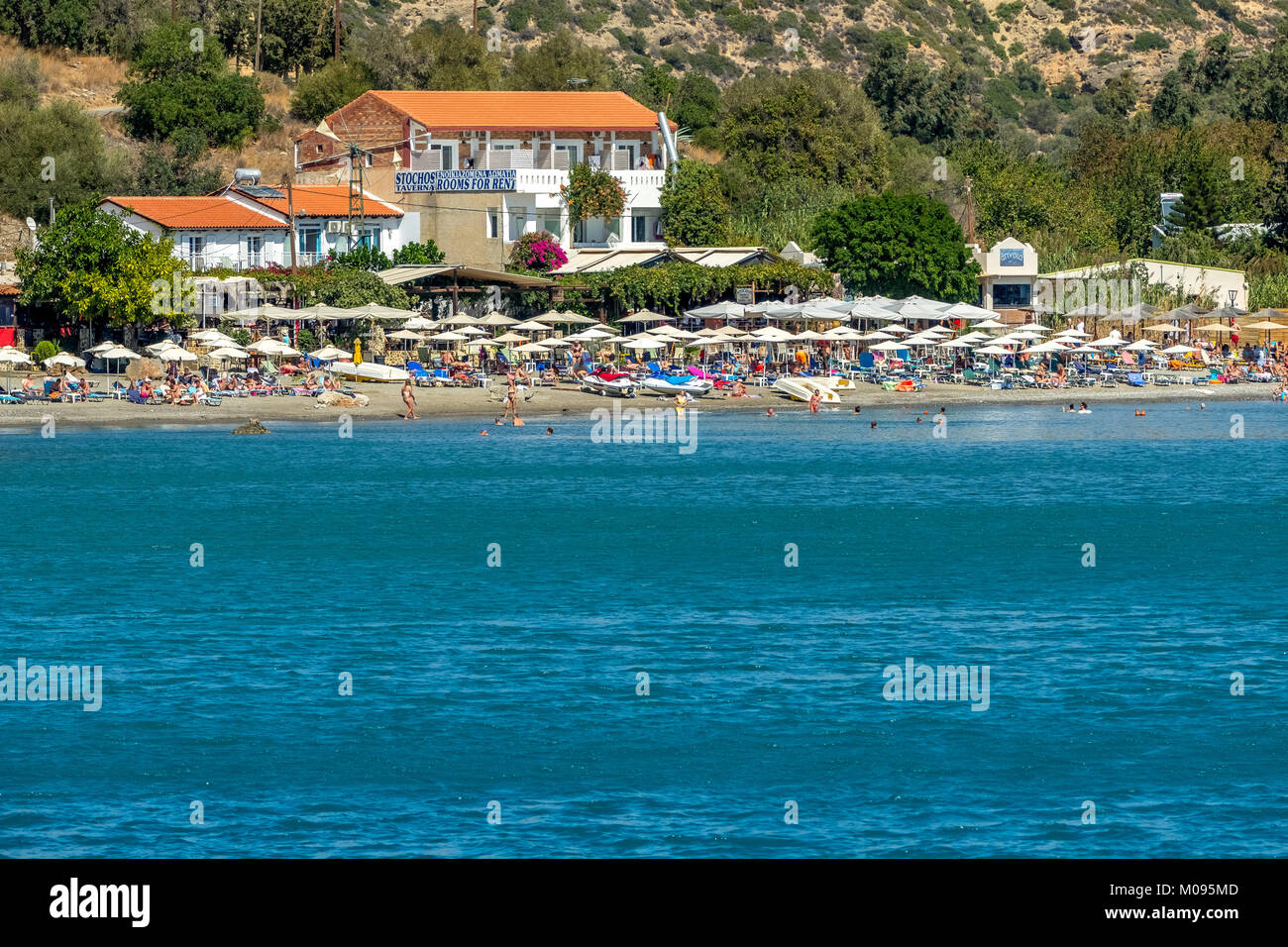 Sandy beach with bathers of Agia Galini, pebble beach, bather in autumn ...
