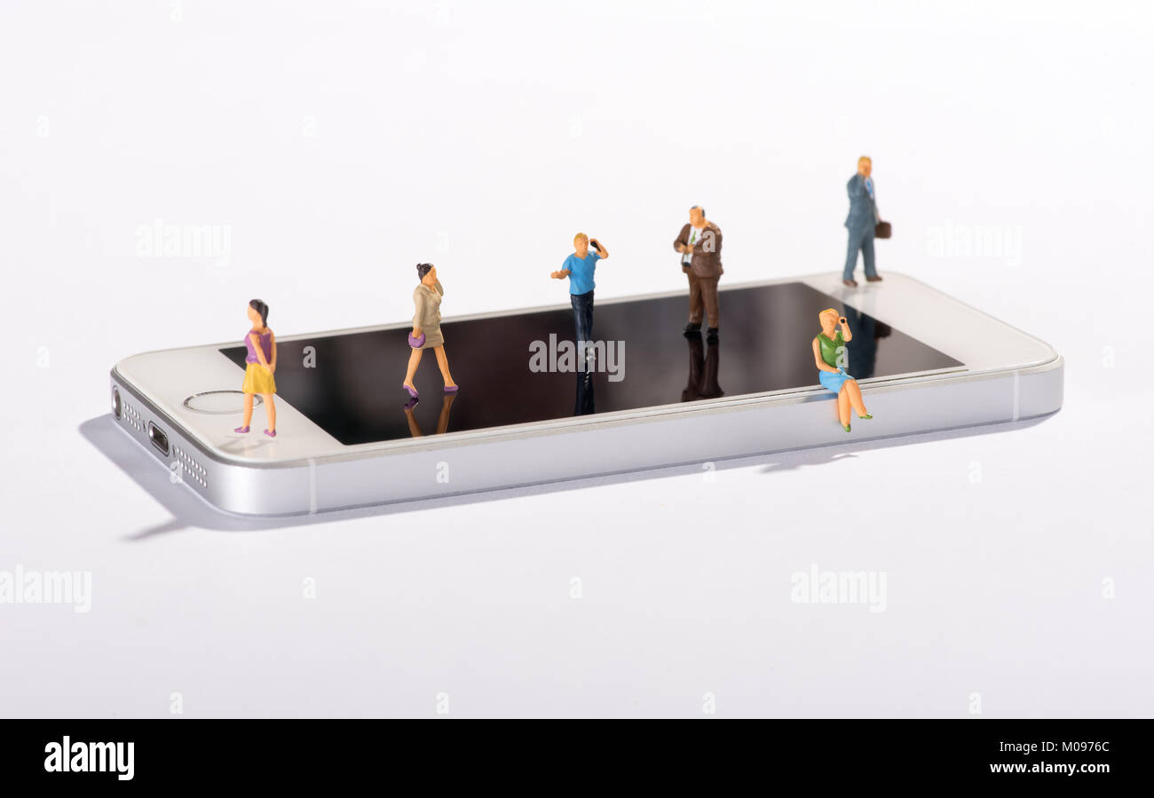 Communications concept with miniature people chatting on mobile phone ...