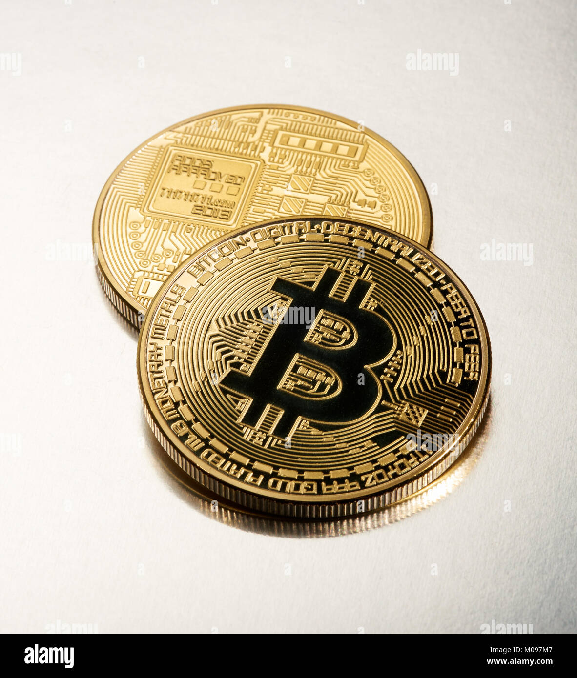 Two gold Bitcoins on a light grey background in a concept of virtual ...