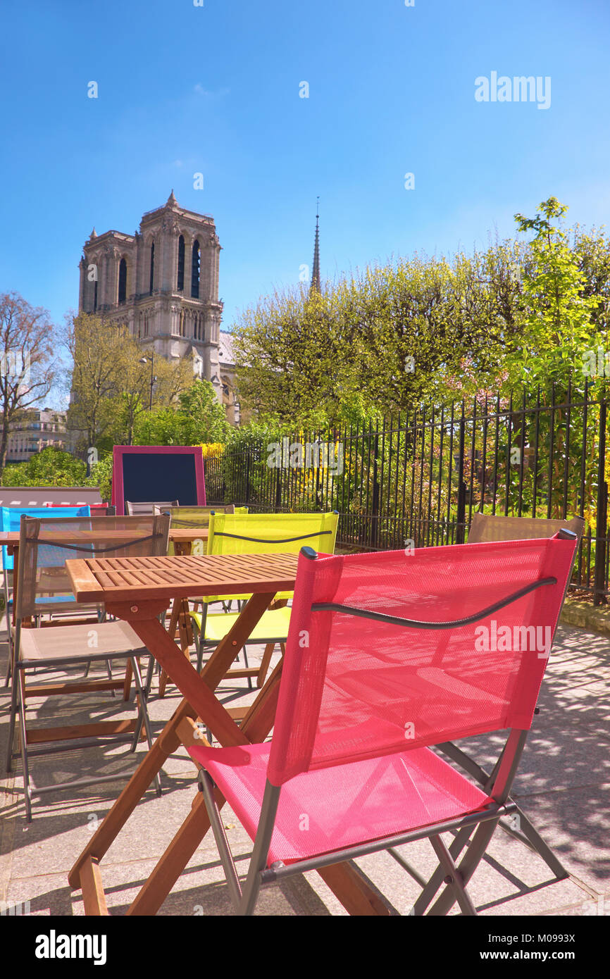 Tables and chairs of an outddoor cafe next to Notre Dame Cathedral in ...