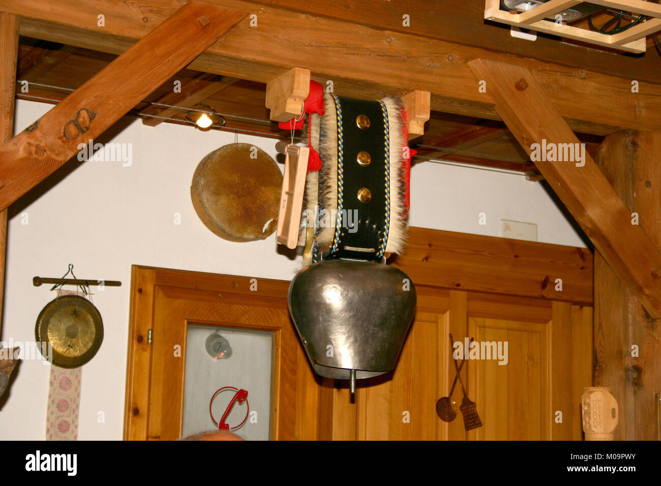 Large cow bell hanging as decoration in Swiss interior Stock Photo - Alamy