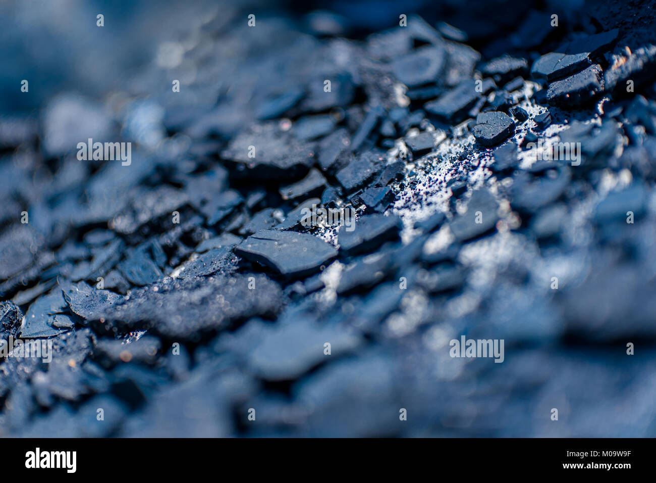 Cracked rocks of indigo paste, dried on the sun, are seen in the metal ...