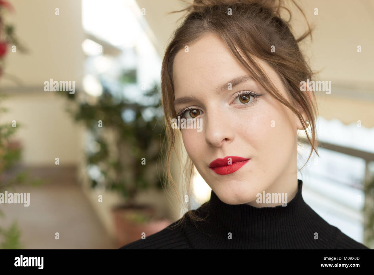 Portrait of a young girl, 16 years, looking at camera, updo hair ...