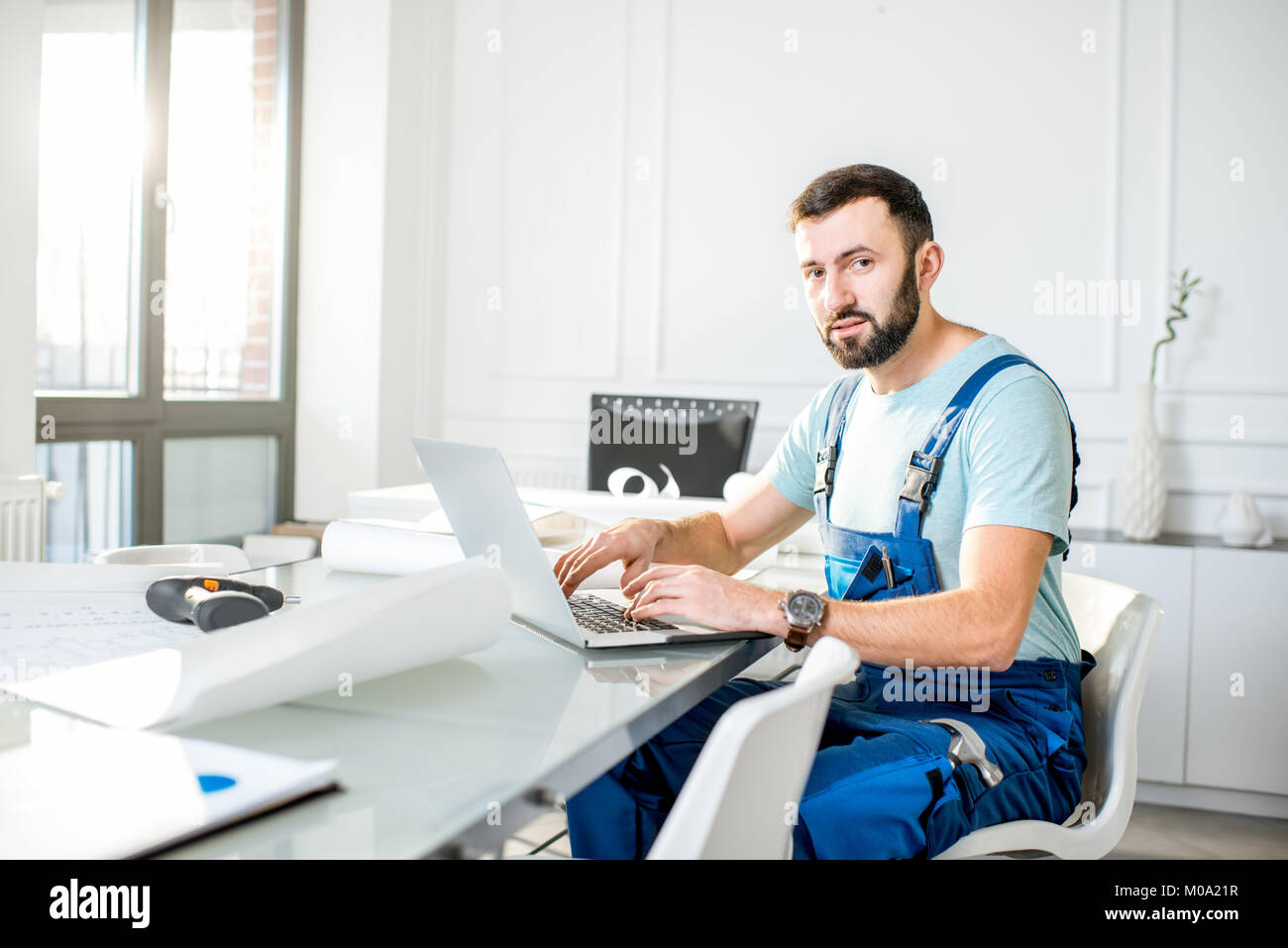 Repairman with paper drawings at the office Stock Photo - Alamy
