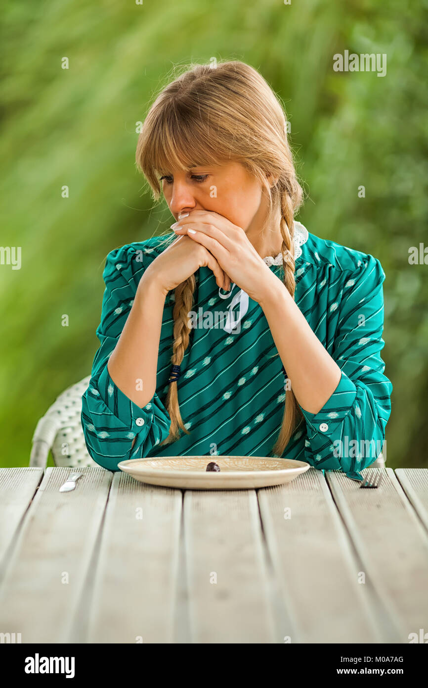 Young lonely woman is having meager meal in times of scarcity Stock ...