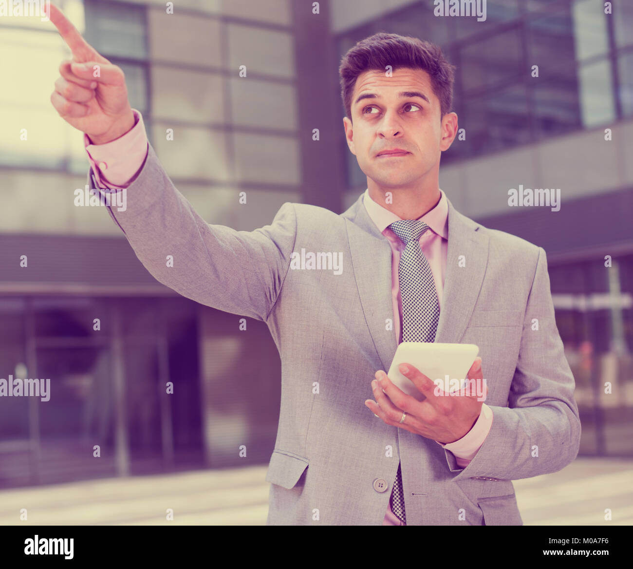 Portrait of manager of plant giving instructions and pointing with his ...