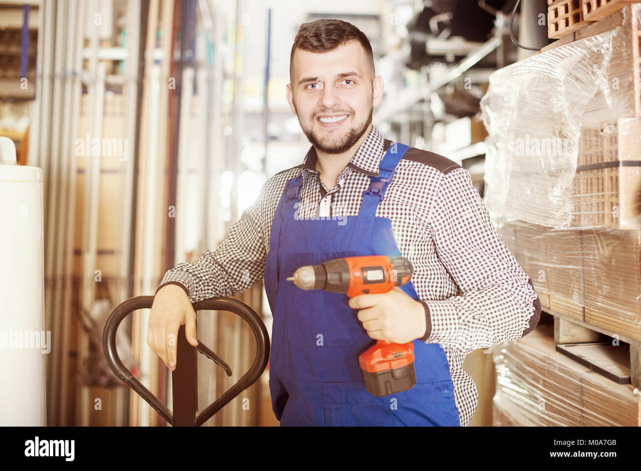 Positive builder male demonstrating various tools at workshop Stock ...