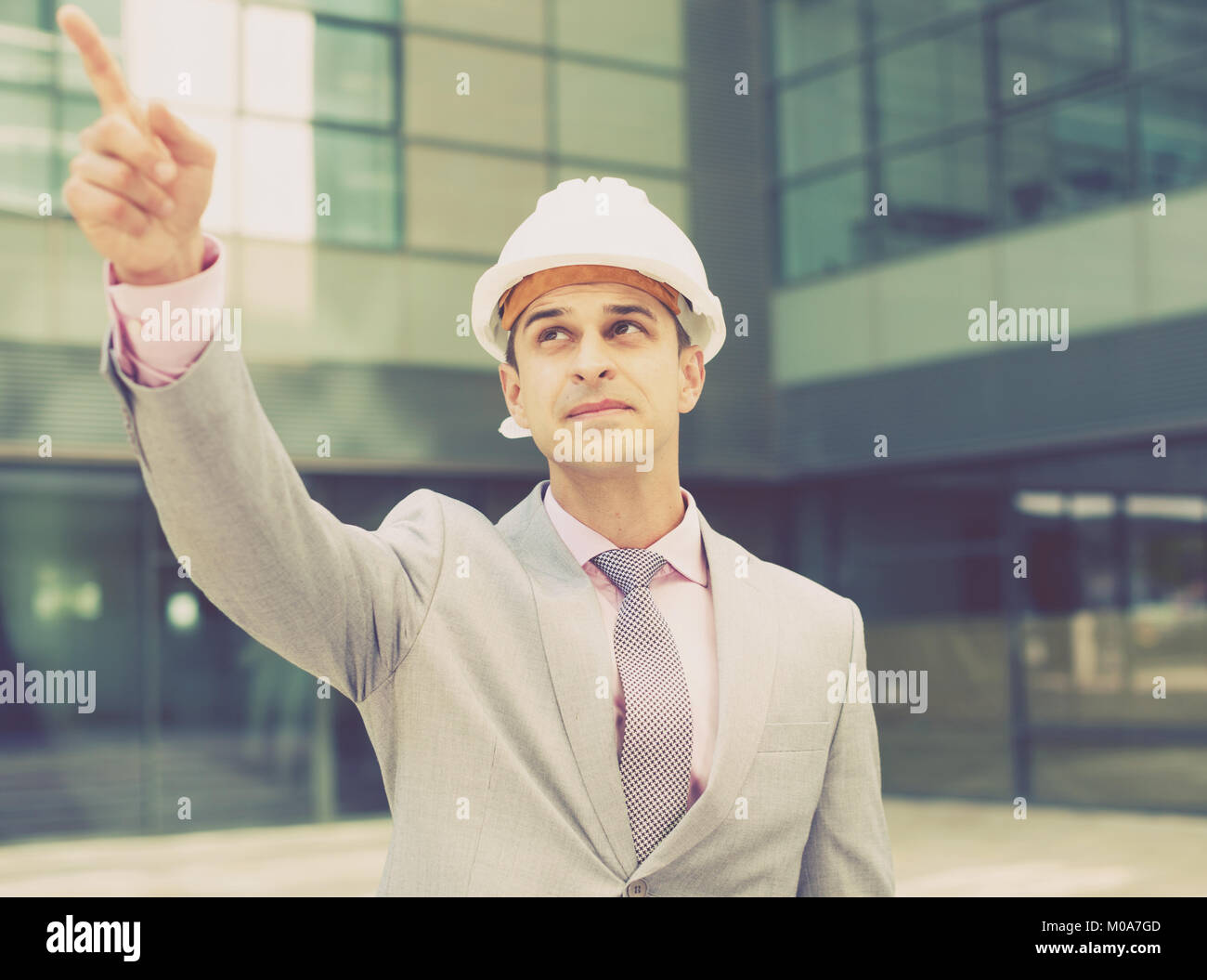 Portrait of manager of plant giving instructions and pointing with his ...