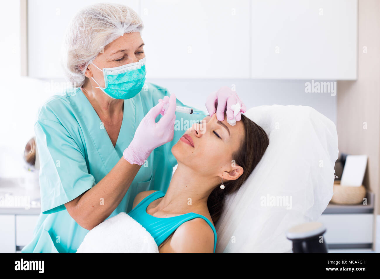 Young woman getting injection for facial correction procedure in ...